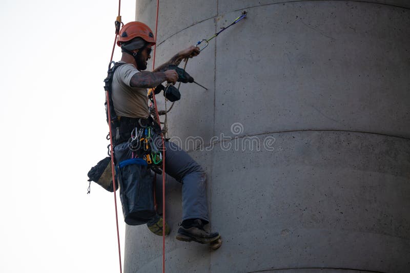 Man Working on Concrete Chimney Using Power Drill Stock Image - Image ...