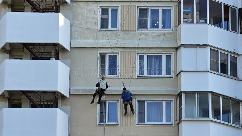 Industrial Climbers Work on the Facade of a Residential High-rise ...