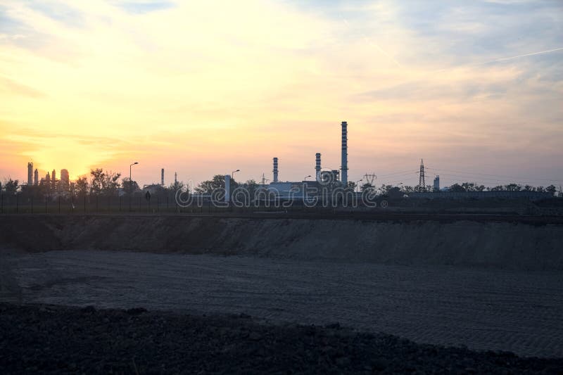 Industrial Complex on the Horizon Beyond a Bare Field at Sunset Stock ...