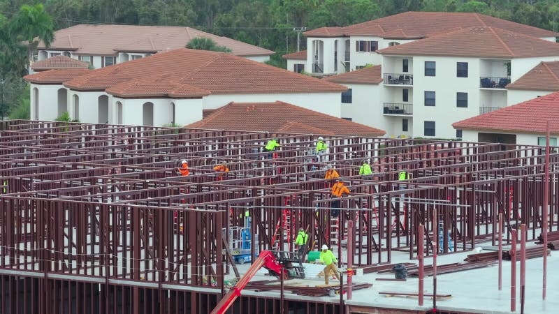 Industrial Construction Site with Workers Assembling Metal Frame Building. Development of ...
