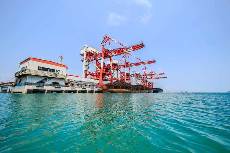 Industrial Crane Unloading Coal from a Barge for Power Plant Operations ...