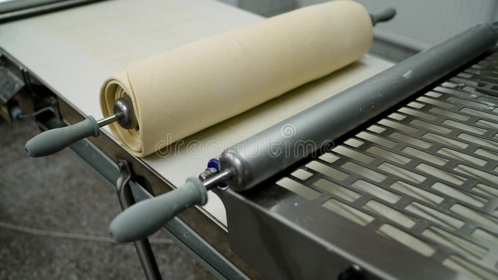 Industrial Dough Sheeter Rolling Dough in a Bakery. Stock Image - Image ...