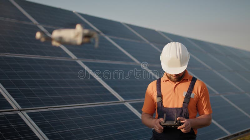 Industrial Expert Wearing Helmet and Controlling Drone in Photovoltaic ...