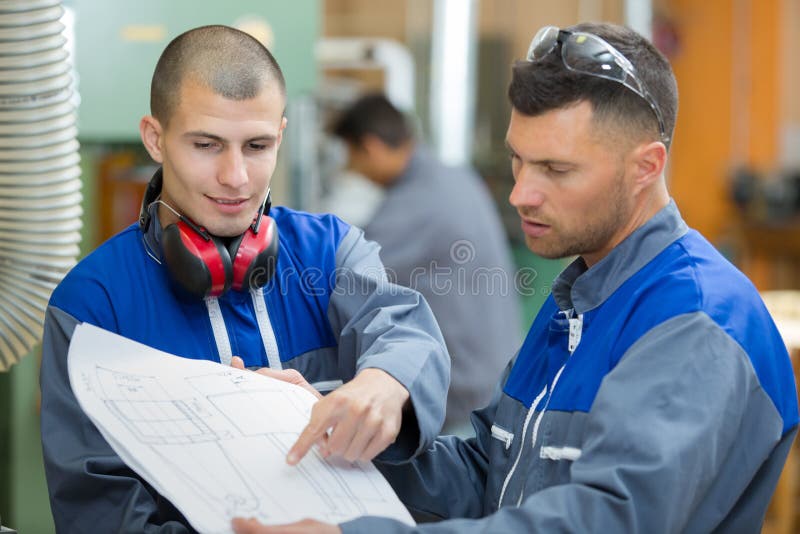 Industrial Manufacturing Workers Reading Engineering Blueprint Stock ...