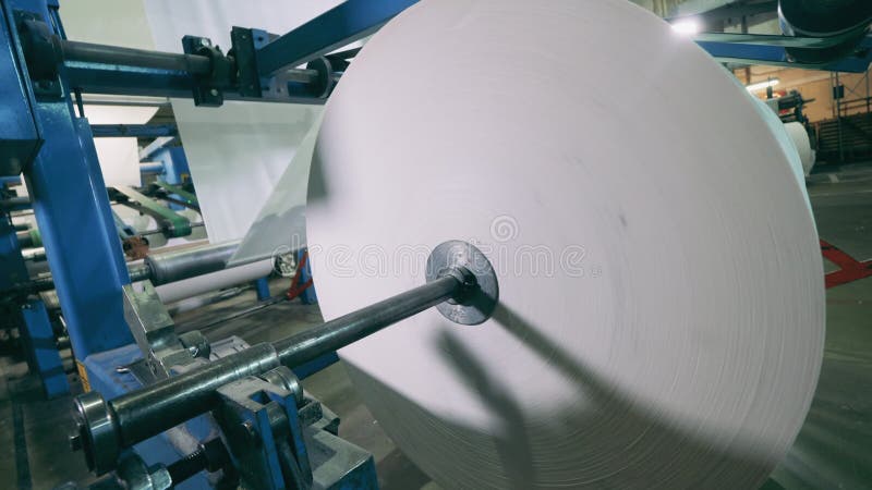 Industrial Mechanism with a Massive Roll of Paper Spinning on it Stock ...