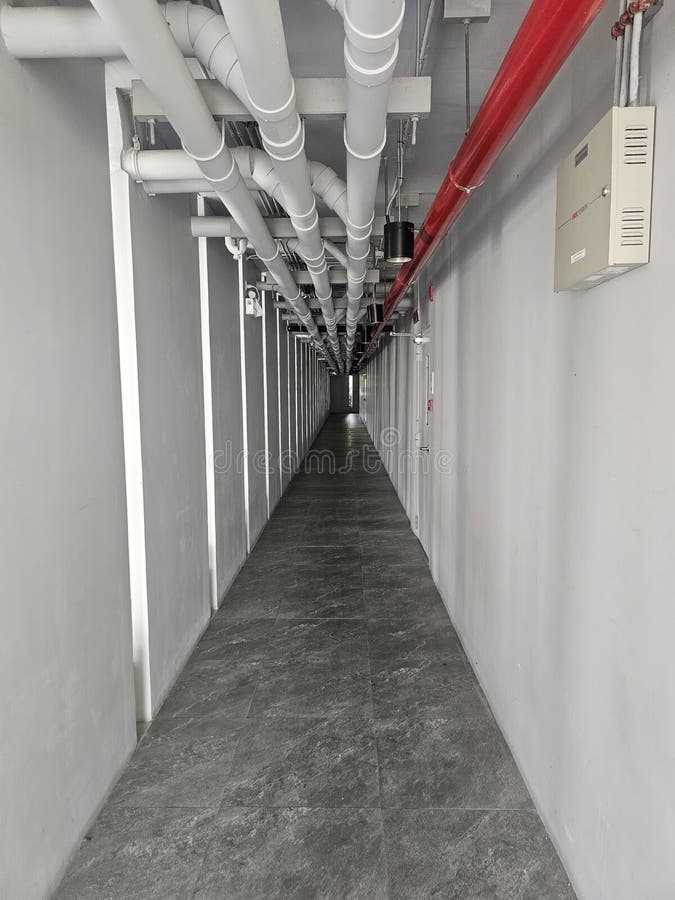 Industrial Pipework and Modern Flooring in a Long Corridor Space Stock ...