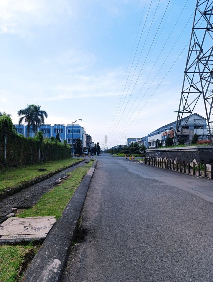 Industrial Road with Power Lines and Buildings Under a Blue Sky Stock ...