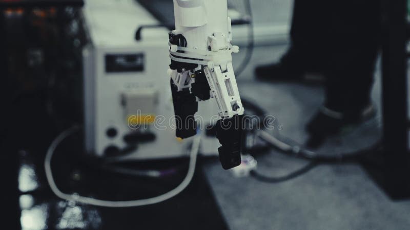 An Industrial Robotics Engineer Diligently Testing And Programming A Robot Arm Using Remote