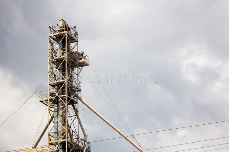 Industrial Steel Tower with Support Beams and Power Lines Under Cloudy ...