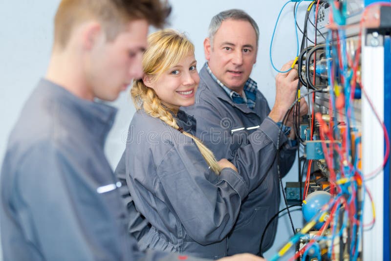 Industrial Technical Female Apprentice and Trainer Looking at Young Man ...