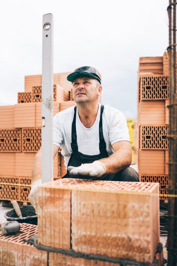 Worker Mason Closely Placing Stone Tile on Vertical Wall. Industry ...