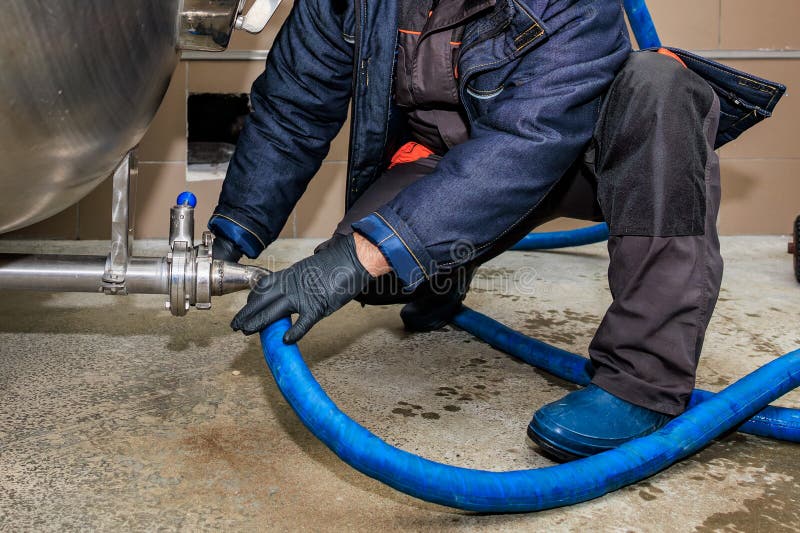 Industrial Worker Handling Blue Hose in Factory Setting Stock Photo ...