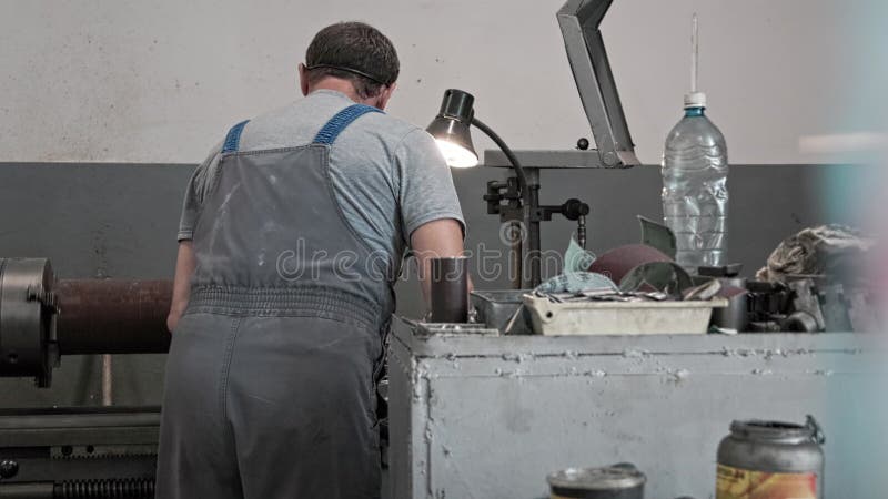 Video 4k. Workshop Scene Showing a Focused Technician Operating a Lathe ...