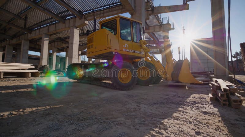 Industrial Yellow Bulldozer Parked Amid Concrete Foundations, Sunlight ...