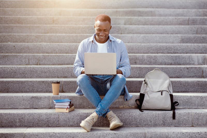 Industrious Black Guy Studying Online with Laptop Computer on Stairs ...