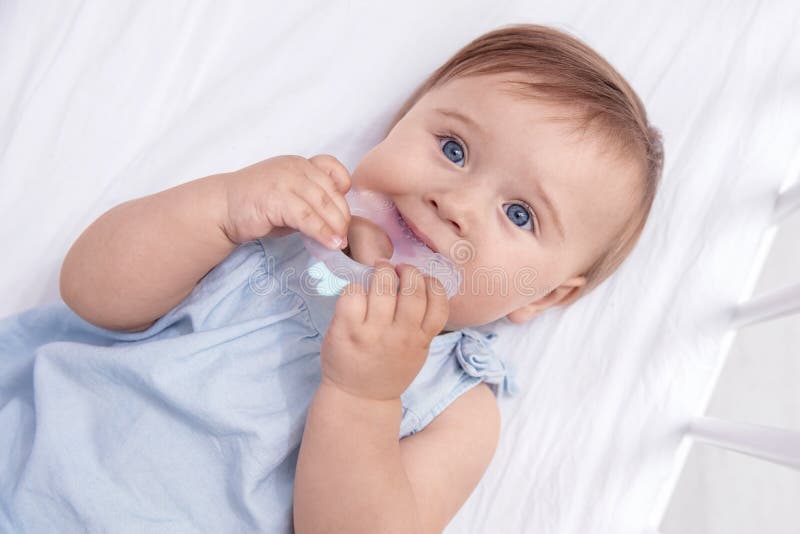 Infant Baby Girl Bites Silicone Teether in Her Bed Stock Photo - Image ...