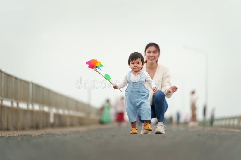 Infant Baby Learn Walking First Step on Pathway with Mother Helping ...