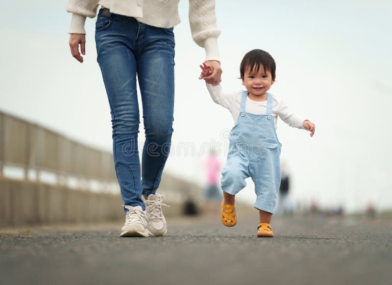 Infant Baby Learn Walking First Step on Pathway with Mother Holding ...