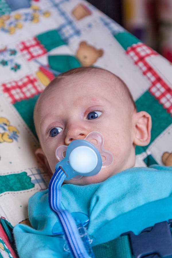 Infant Boy with a Pacifier Lying Down and Looking To the Side. Stock ...