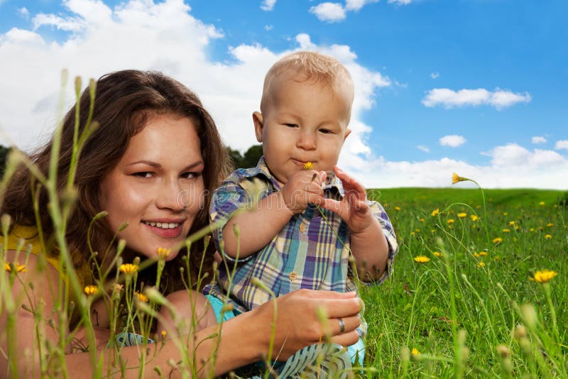 Infant sniffing the flower stock image. Image of park - 26979717
