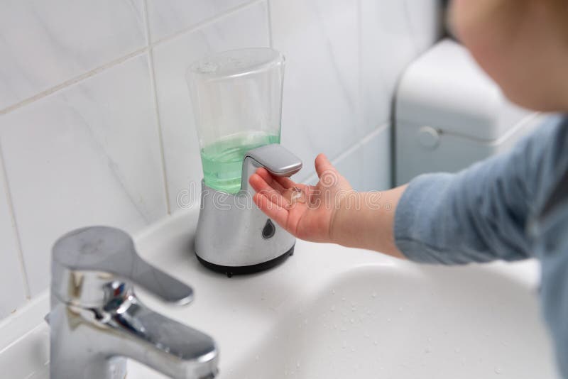 Infant Using a Soap Dispenser on a White Sink Stock Photo - Image of ...