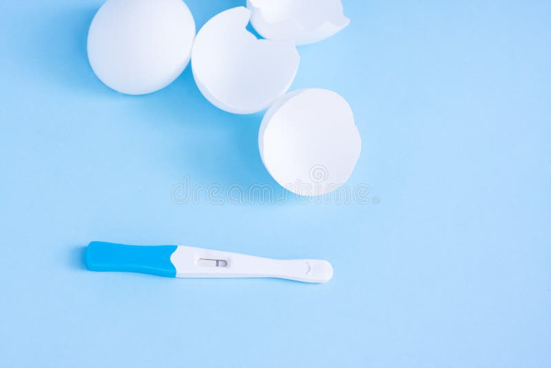 Infertility. Negative Pregnancy Test and Eggshell on Blue Stock Image ...