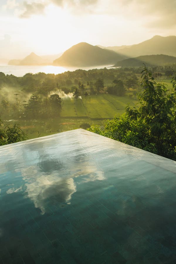 Infinity Pool with Amazing Mountain and Ocean View at Sunset Stock ...