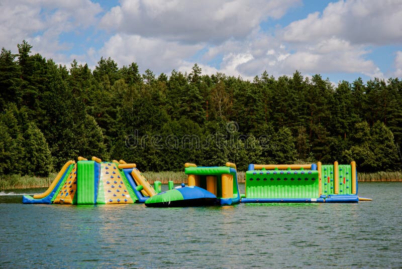 Inflatable Obstacle Course on Lake with Forest Backdrop for Summer Fun ...