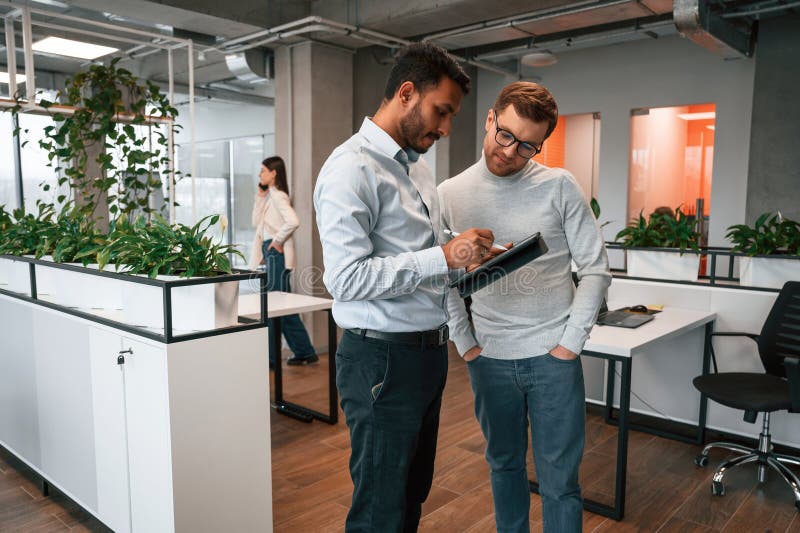 Information in the Tablet. Two Men are Working in the Modern Office ...
