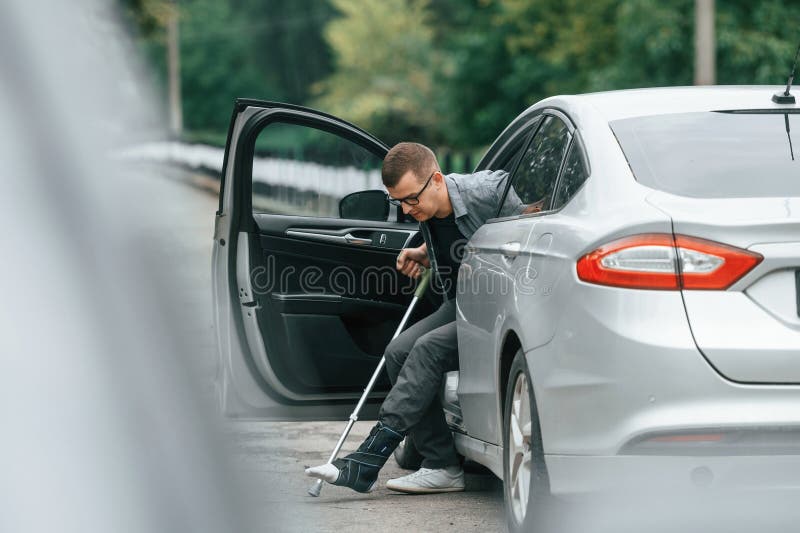 Injured Man with Crutches is Going Out from the Car Stock Photo - Image ...