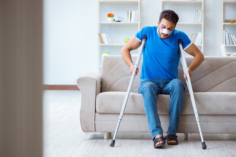 The Injured Man with Crutches Recovering at Home Stock Photo - Image of ...