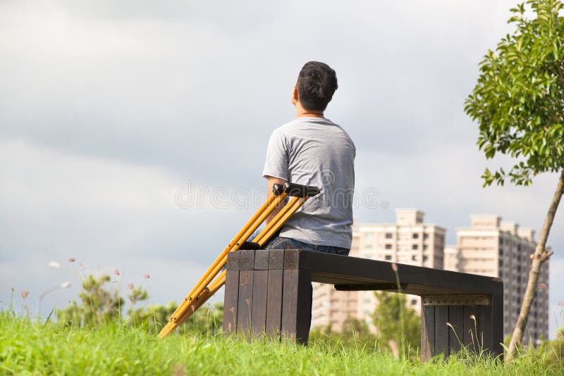 Injured Man with Crutches Sitting on a Bench Stock Photo - Image of ...