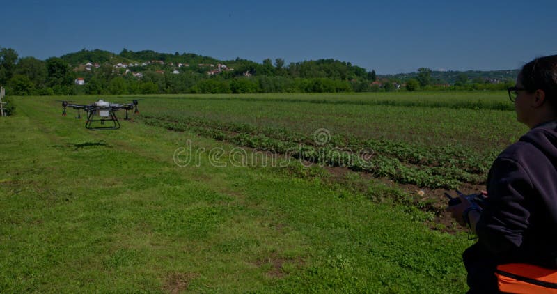 An Innovative Female Farmer Operates a Drone while Standing in the ...