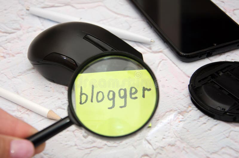 Inscription Blogger through a Magnifier, Phone, Computer Mouse and Pen ...