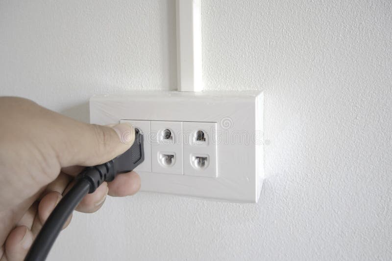 Inserting the Plug into the Socket. the Man Holds a Black Plug in His ...
