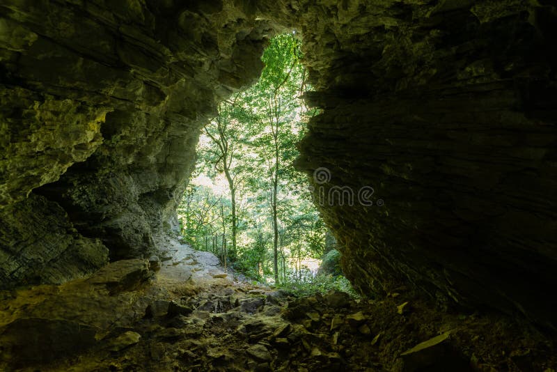 Inside a Dark Wet Cave with the Illuminated Exit in Sight Stock Image ...