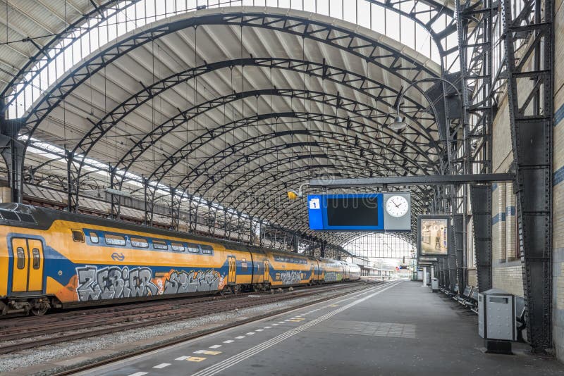 Inside of a Dutch Central Train Station with a Yellow and Blue Train ...