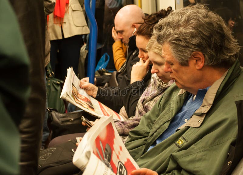 People Reading Newspaper On Train