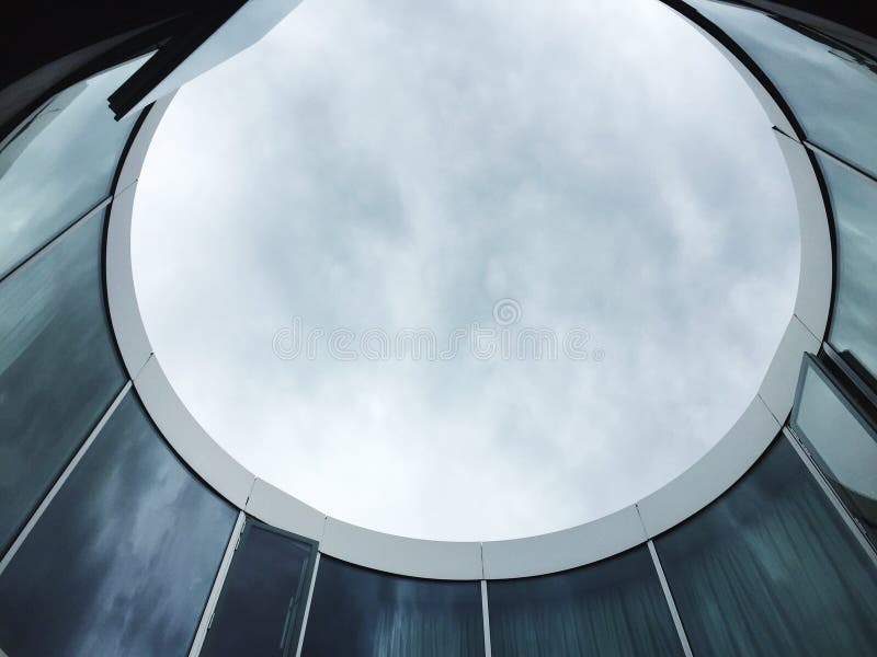 The Inside of a Round Building in a Glass Facade with a Cloudy Sky in ...
