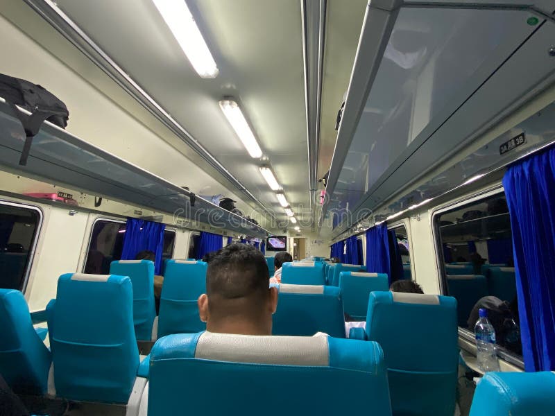 Inside a Train Carriage with Blue Seats and Passengers Enjoying a Night ...