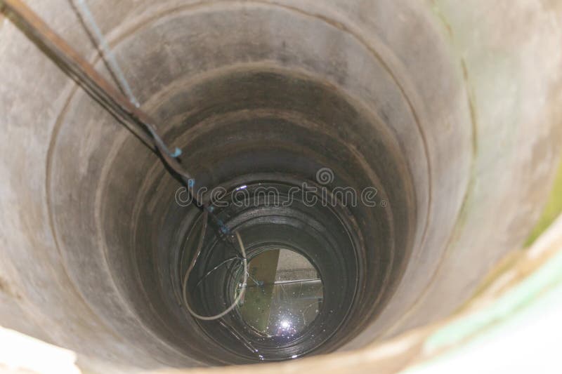 Inside View of a Deep Well with Reflections on the Water Surface Stock ...