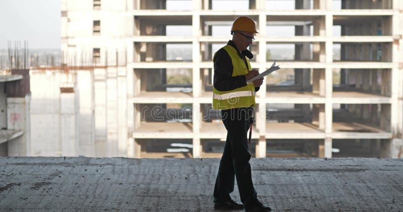 Inspecting Officer Walks on Construction Site and Makes Notes in His ...