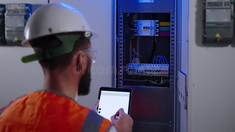 Inspection of Switchboard. Electrician with Digital Tablet Checking ...
