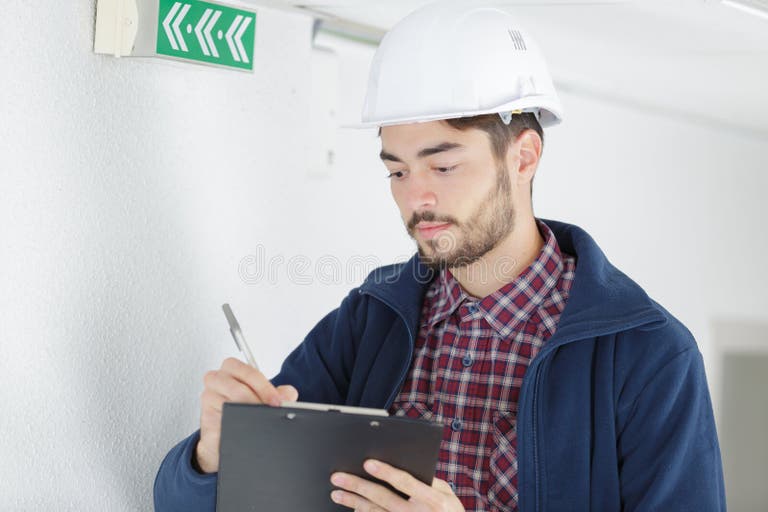 Inspector Next To Fire Escape Sign Making Notes on Clipboard Stock ...