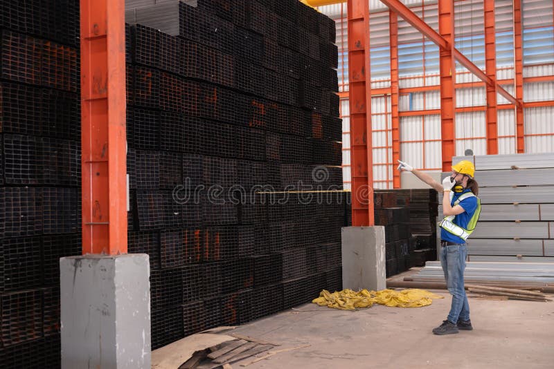 Inspector Pointing To Stack of Steel Bars in a Warehouse Stock Photo ...