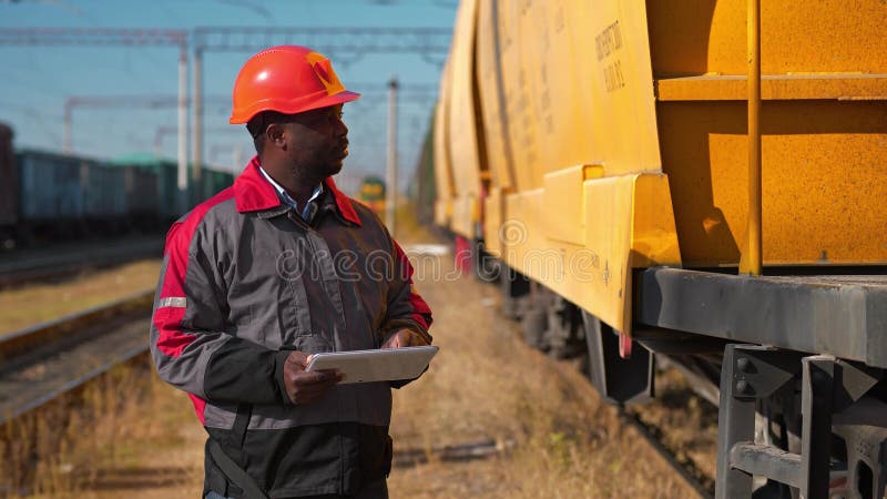 Inspector of Wagons at Freight Train Station Makes Notes in His Tablet ...
