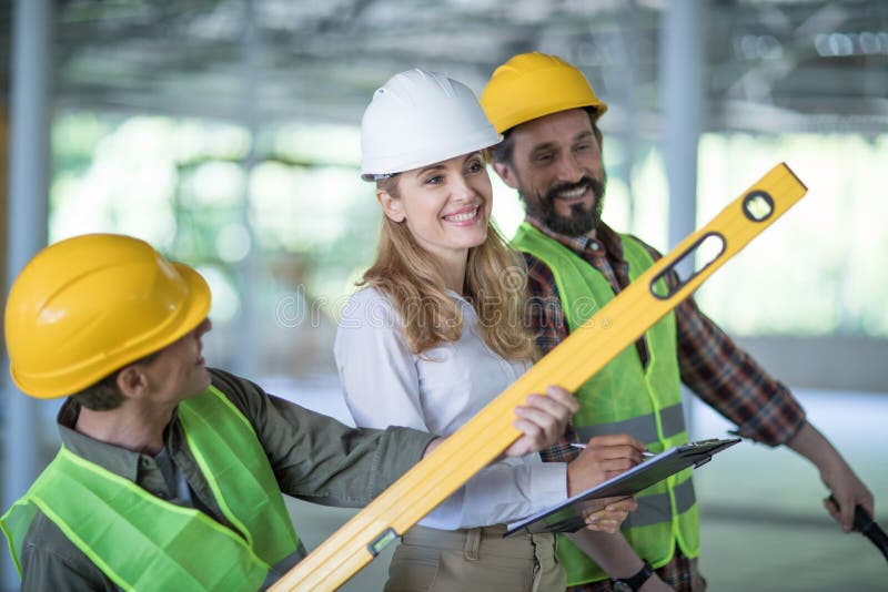 Inspector Writing on Clipboard while Standing with Workers Holding ...