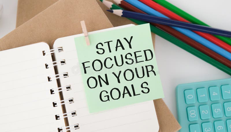 Stay Focused On Your Goals With Text Message On White Paper Book Pen