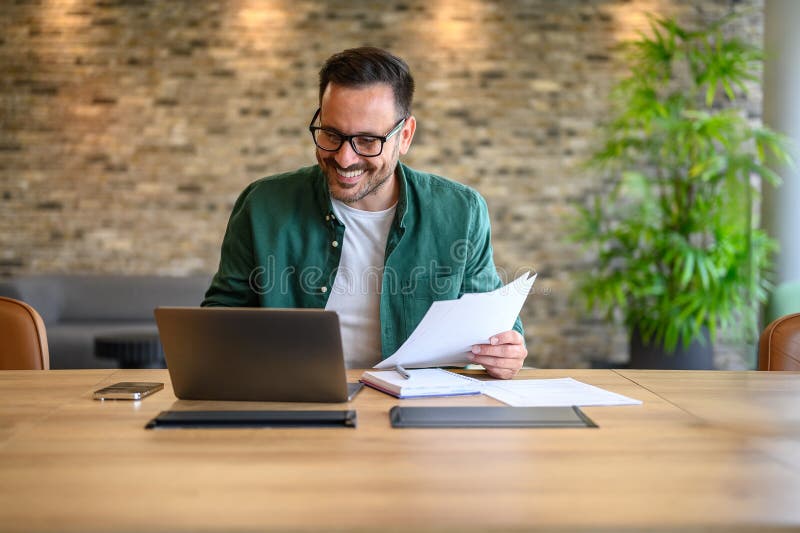 Inspired Businessman with Project Reports Smiling and Working Online ...