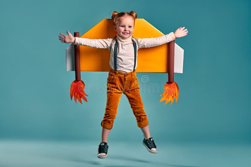 Inspired Kid with Cardboard Wings Jumping on Blue Background with Smile ...